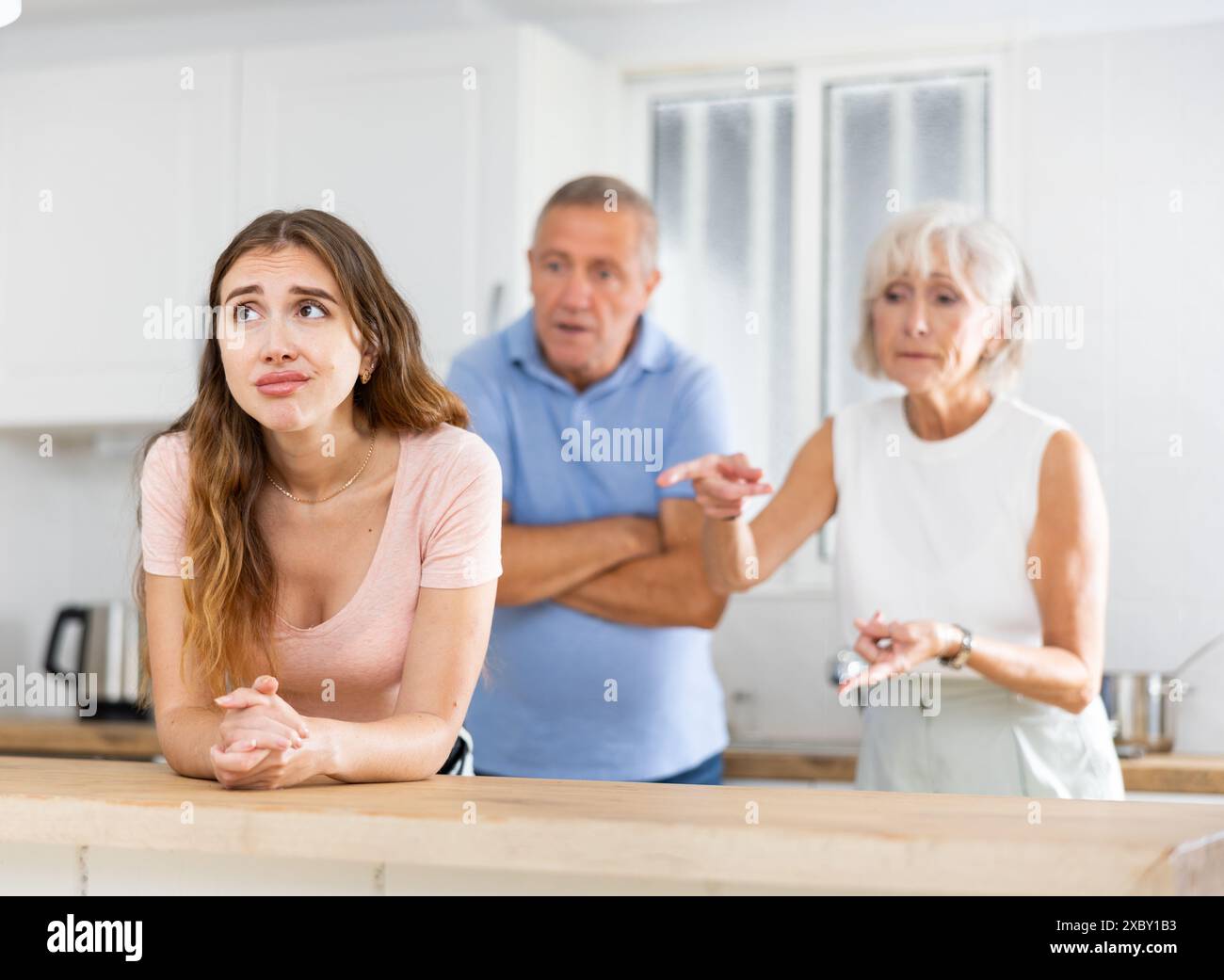 Elderly parents scold adult daughter in kitchen Stock Photo - Alamy