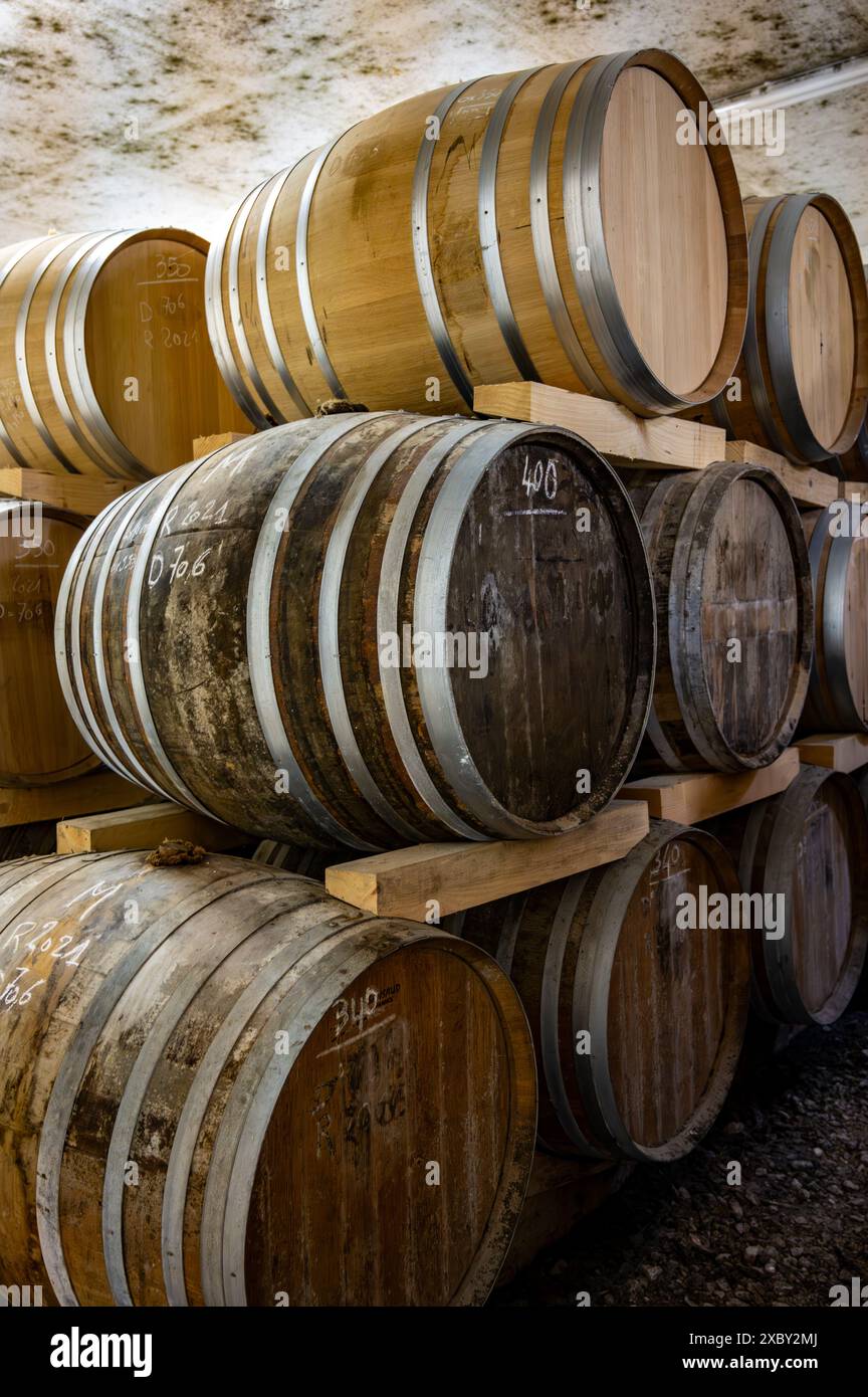Aging process of cognac spirit in old dark French oak barrels in cool ...