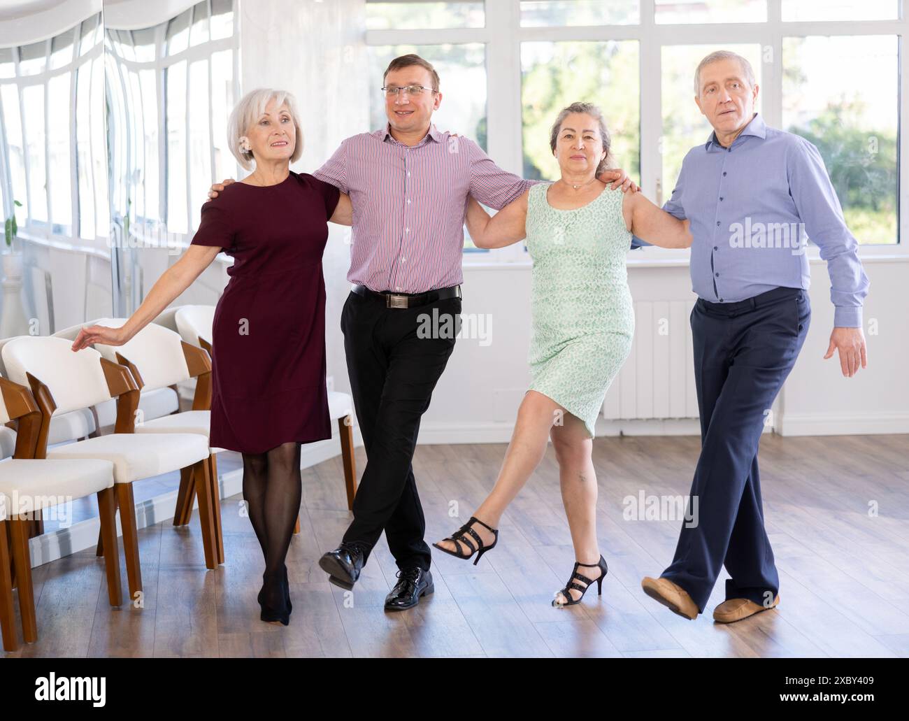 Group of elderly people with middle-aged man perform Irish folk dance ...