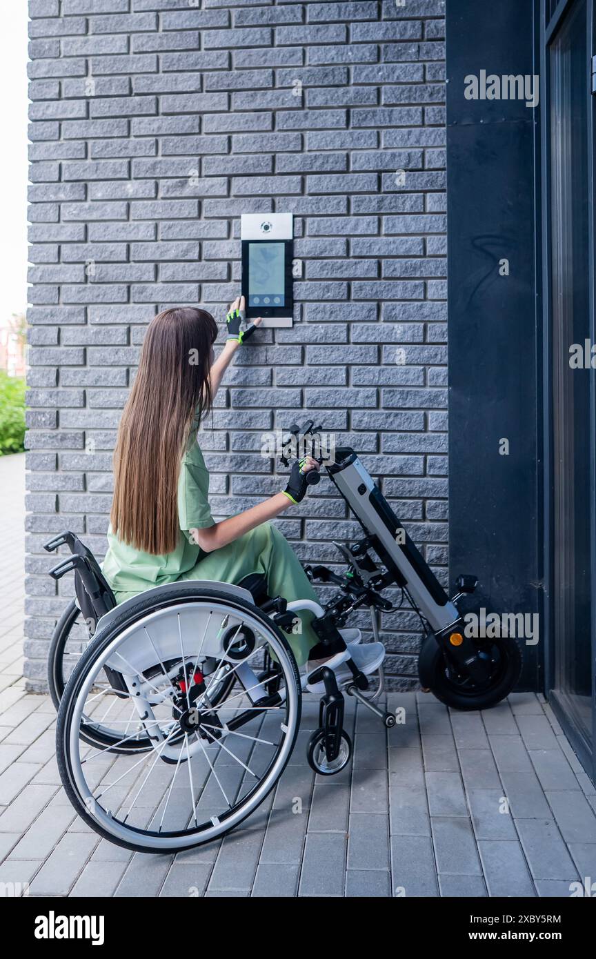 A woman in a wheelchair with an assistive device for manual control ...