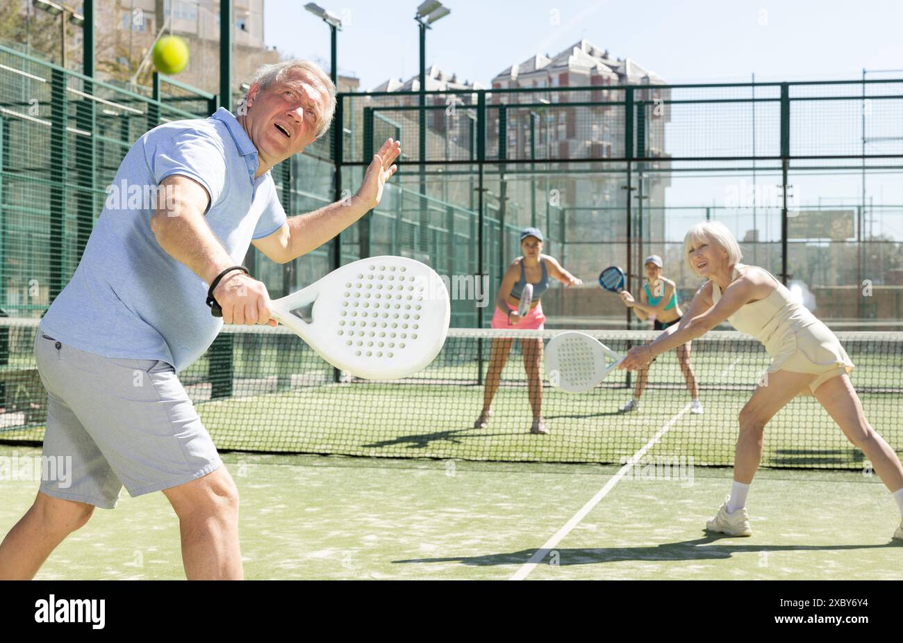 Mature sporty man playing padel game in court on sunny day Stock Photo ...