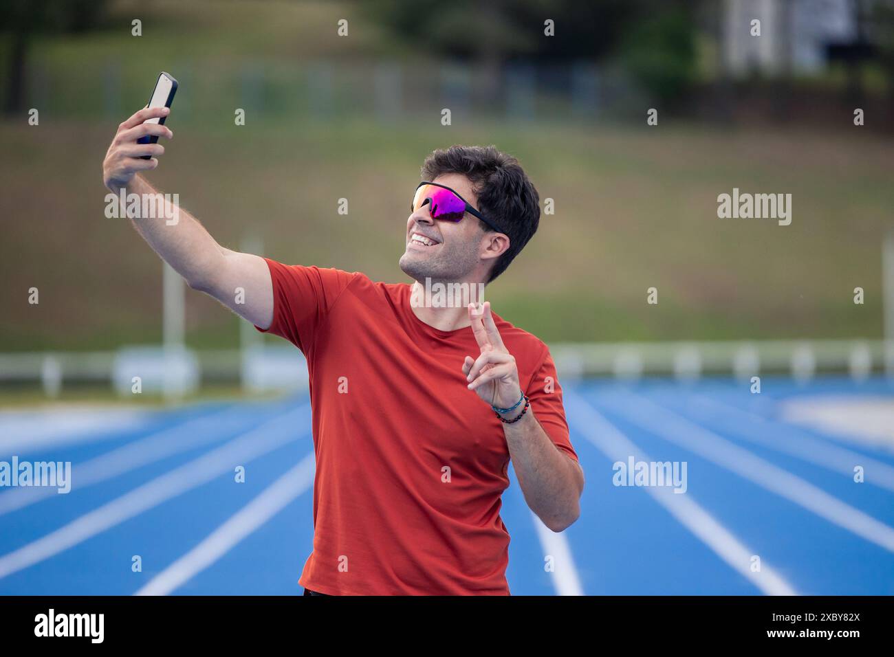 runner wearing sunglasses takes a selfie with a smartphone while ...
