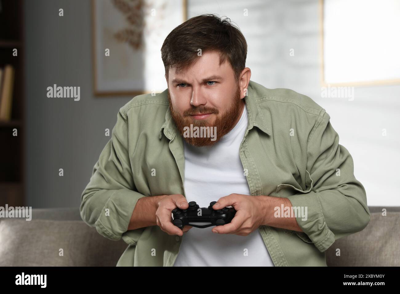Emotional man with game controller at home Stock Photo - Alamy