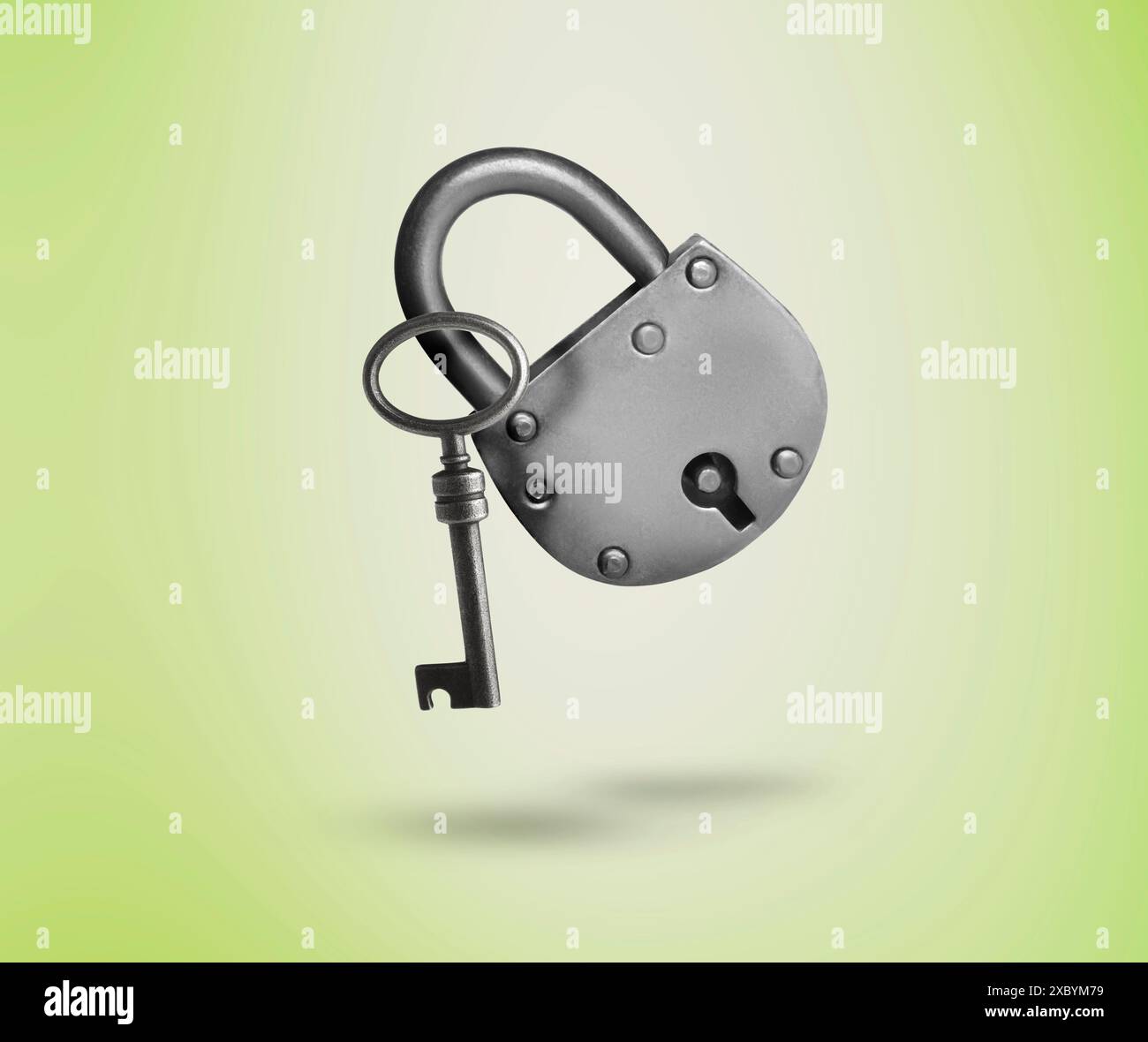Padlock and key in air on green background Stock Photo - Alamy