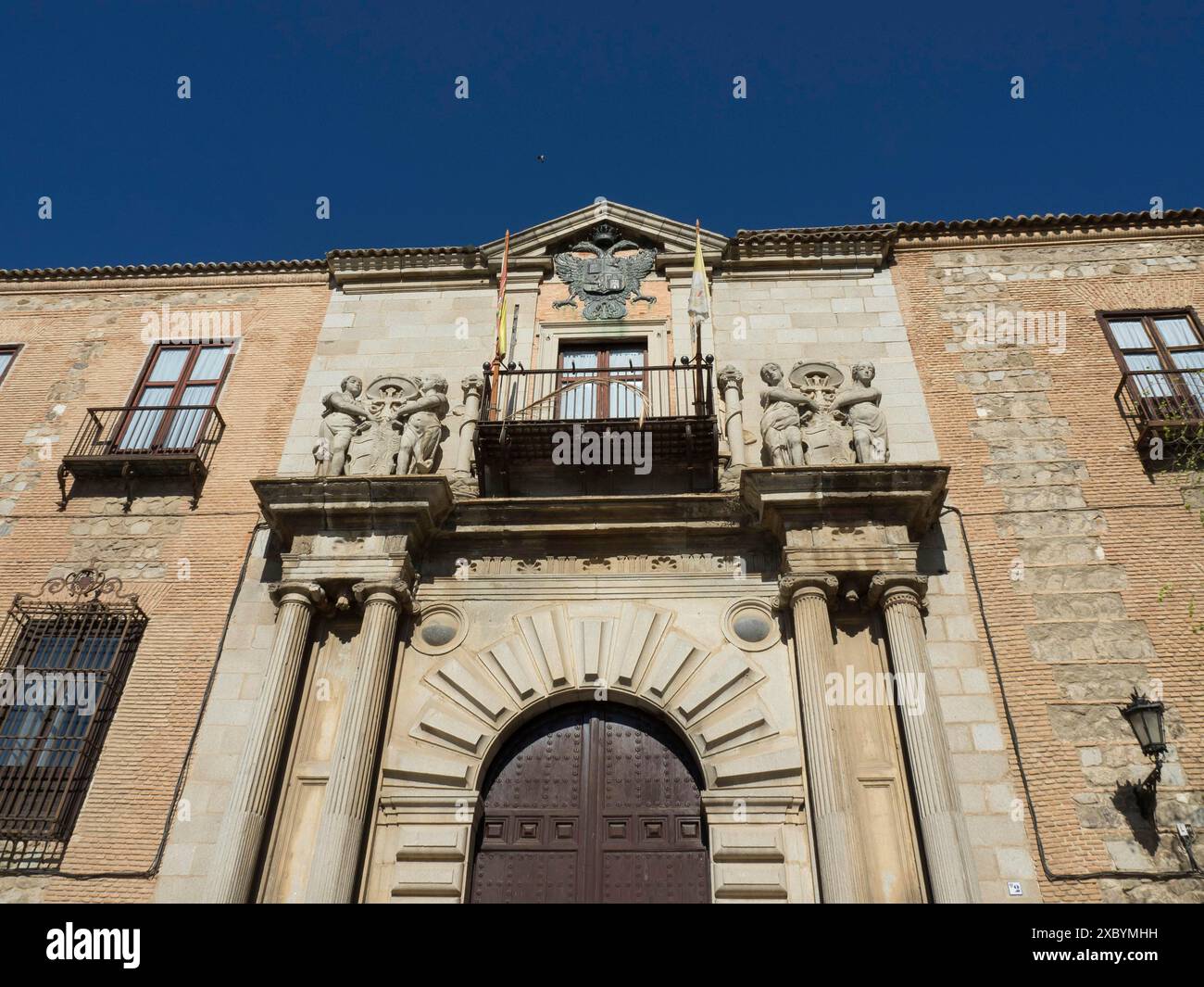 Historic building with relief sculptures and columns, bright blue sky ...
