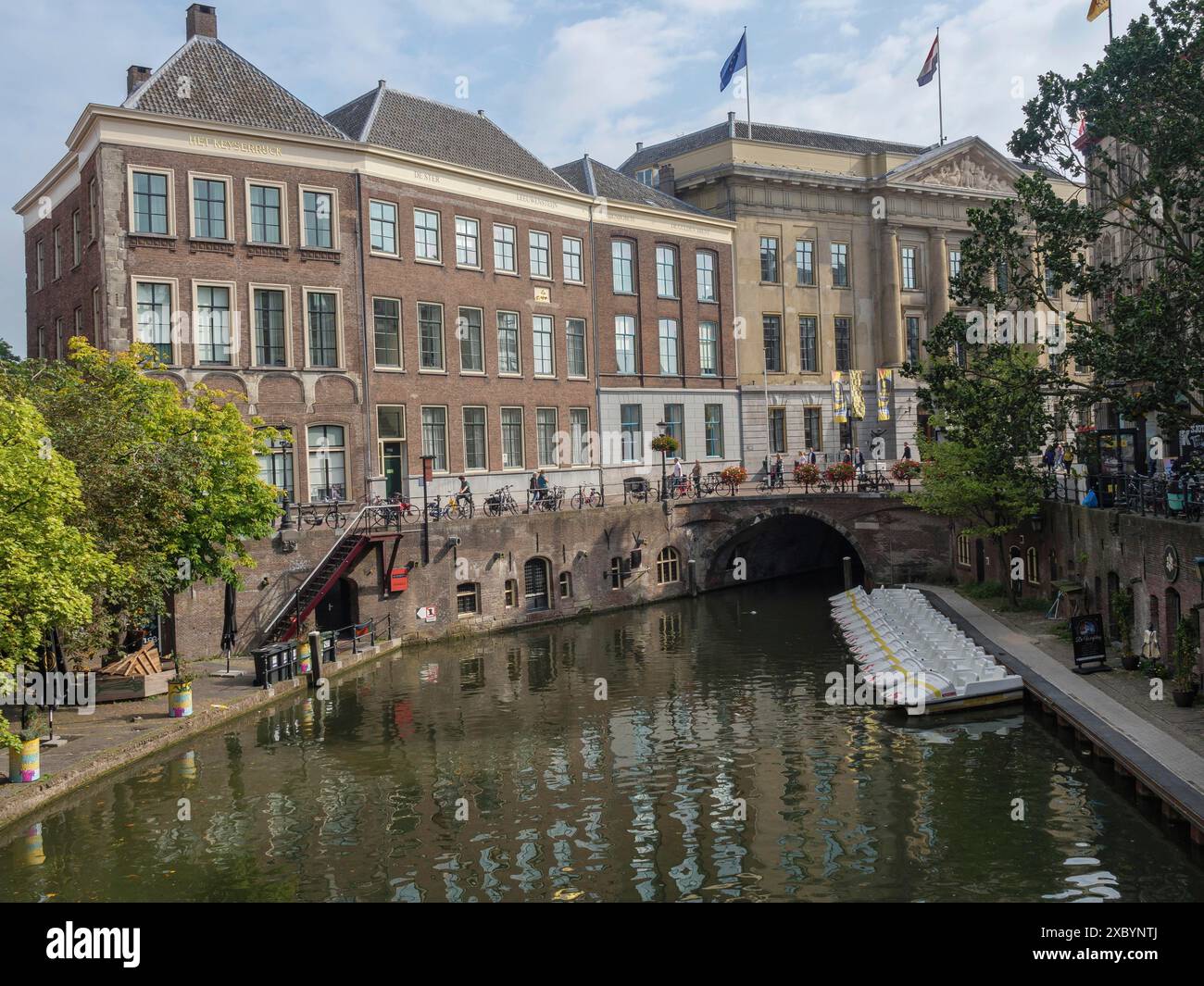 Canal scene with historic buildings, cafes, bridge and docked boats on ...
