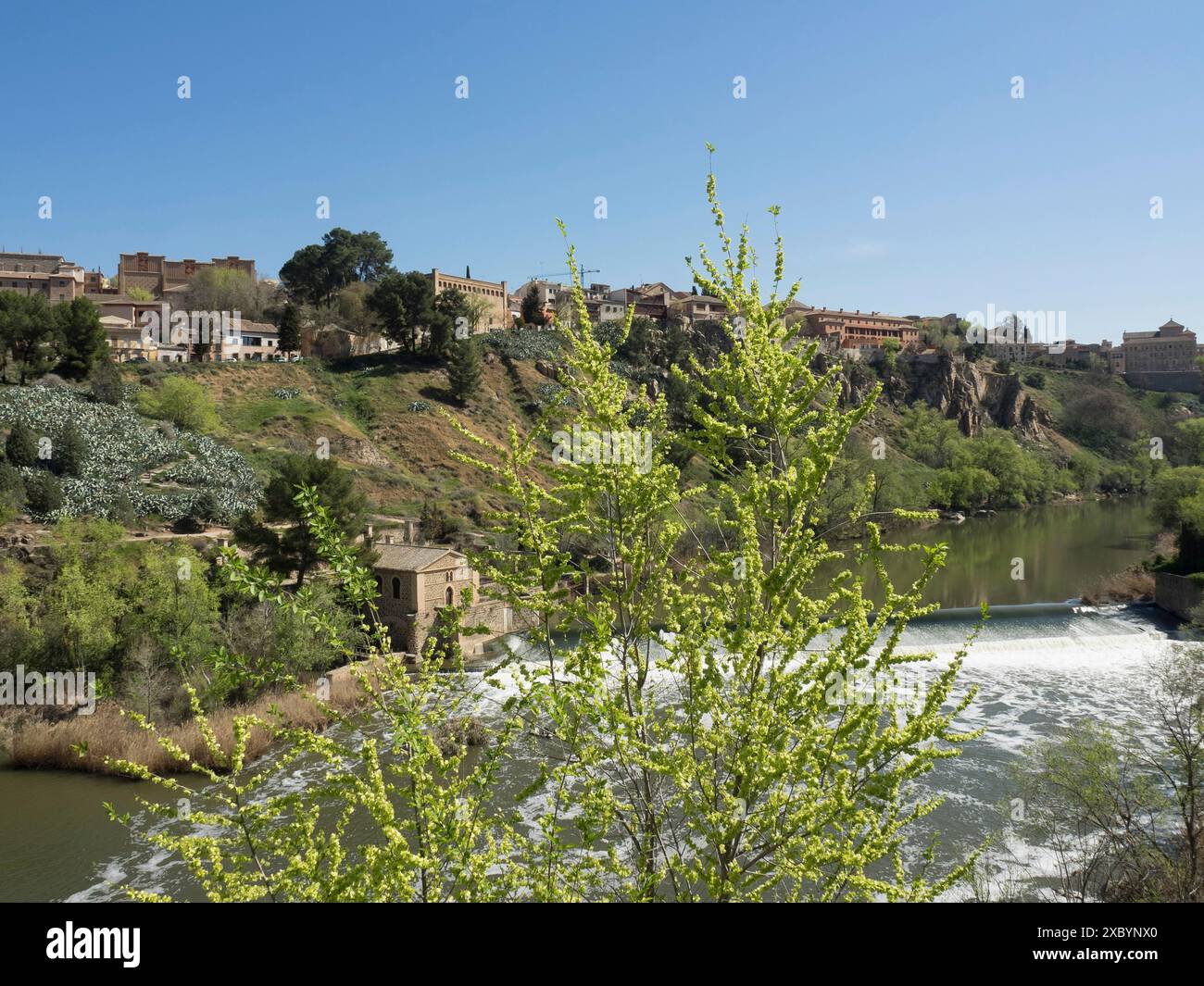 River with waterfall and green hill in the background, spring day with ...