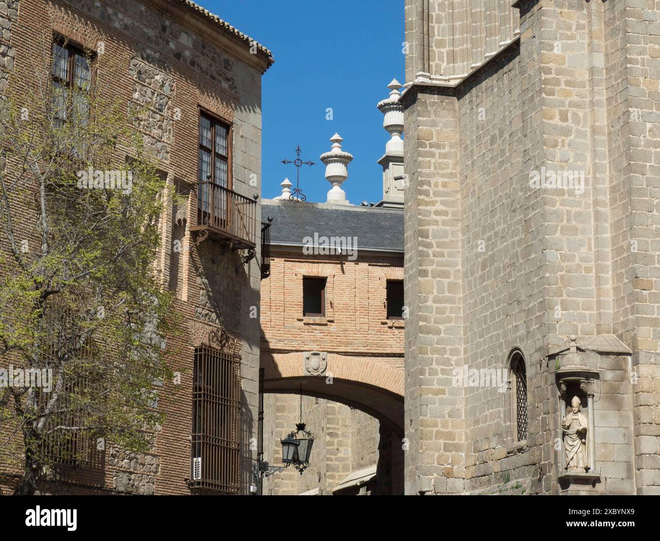 Narrow alley with old brick buildings and a blue sky in the background ...