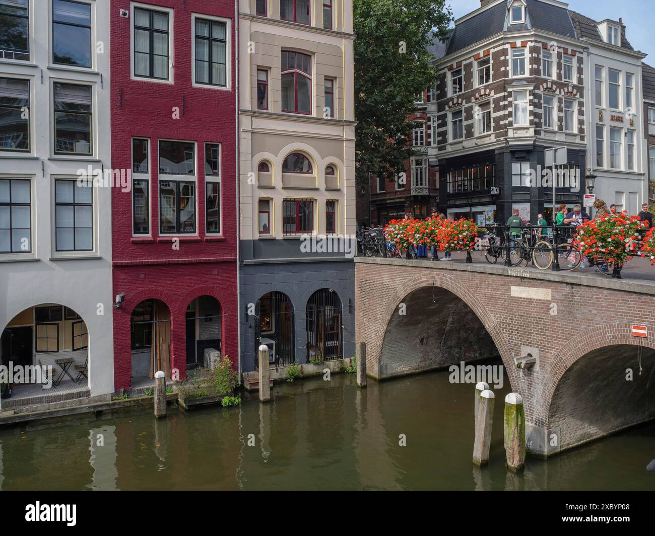 City view with a bridge over a canal, many flowers and multi-storey ...
