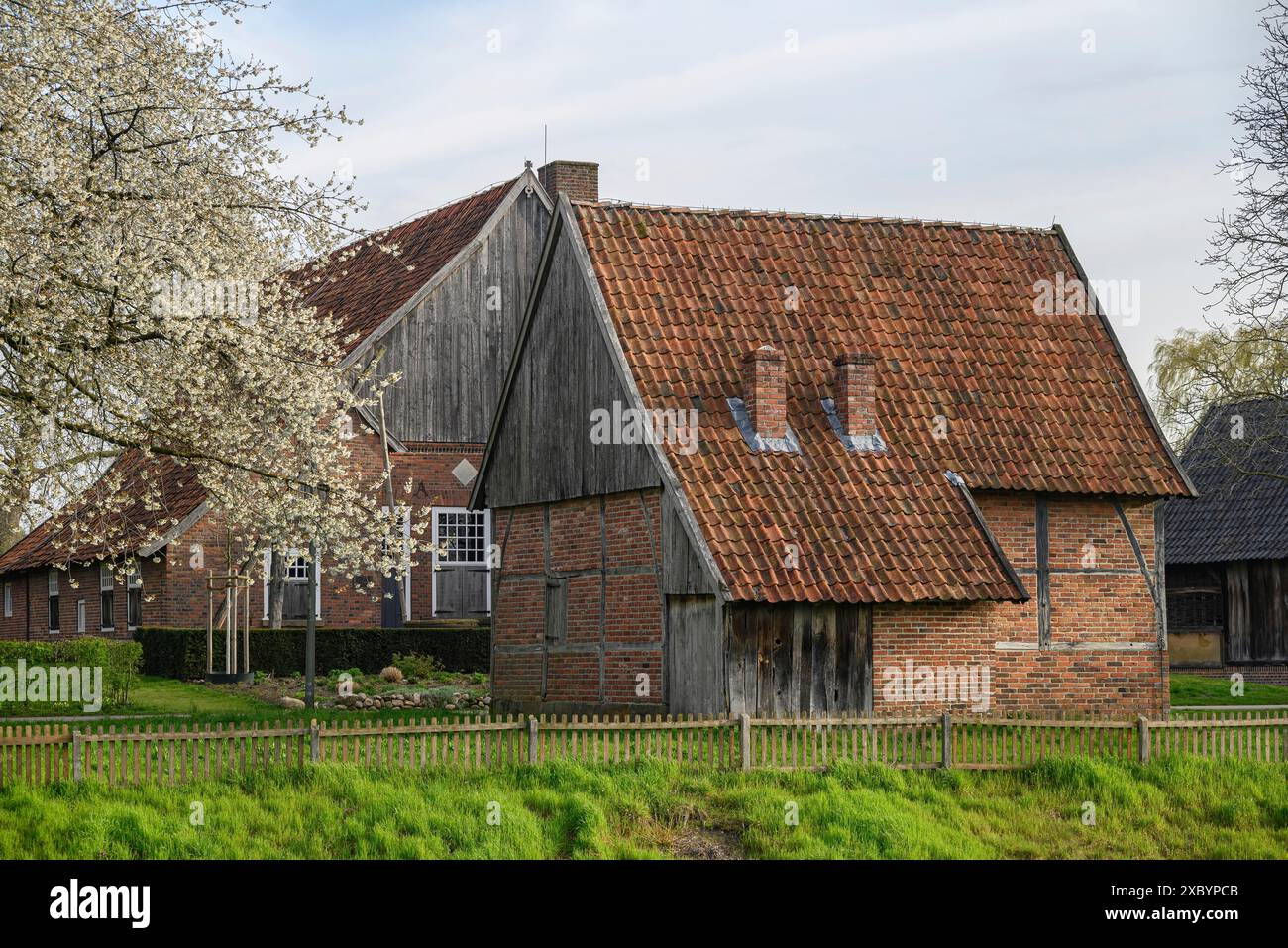 Rustic farmhouse with a red tiled roof and wooden panelling next to a ...