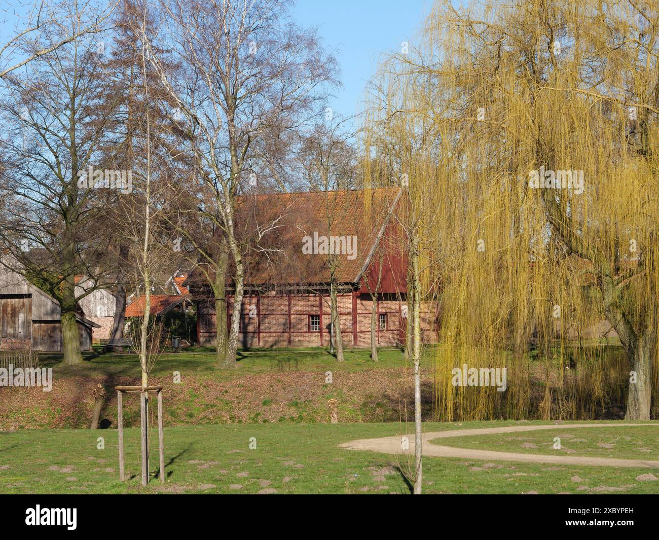 Wooden building in a rural setting with meadow and willow trees ...