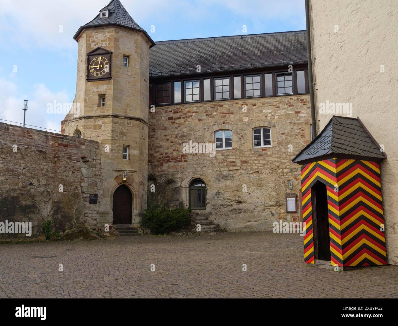 Historic castle with tower clock and colourfully painted guardhouse in ...