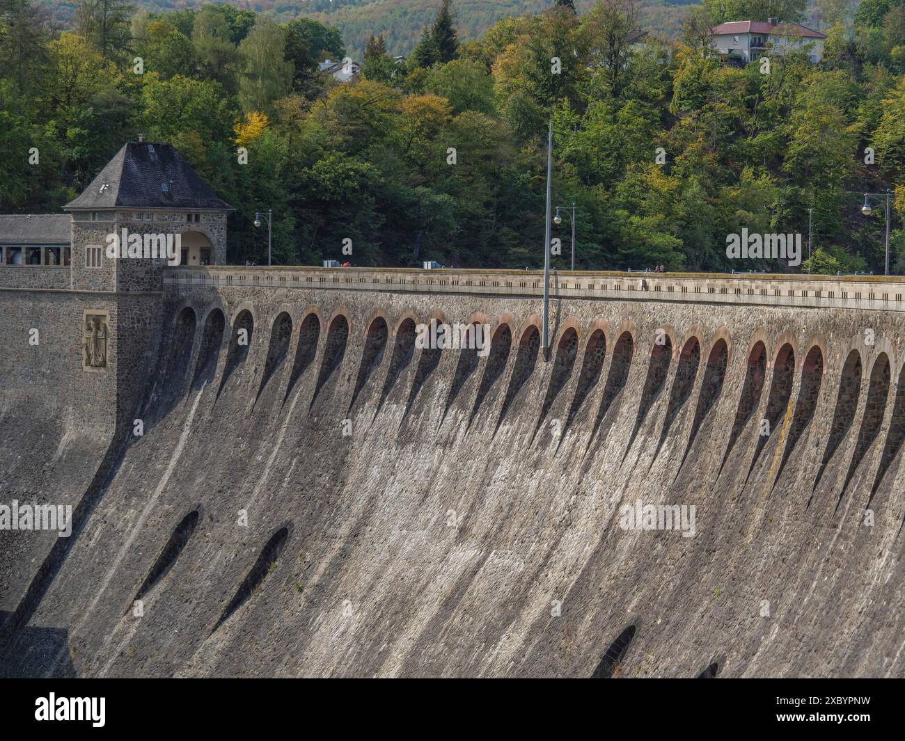 Detailed view of the stone structure of a dam, surrounded by forests ...