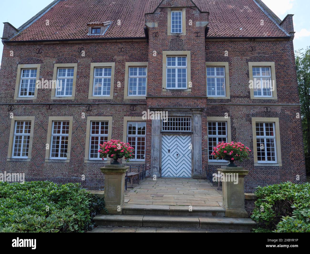 Large, multi-storey brick building with many windows, two flower pots ...