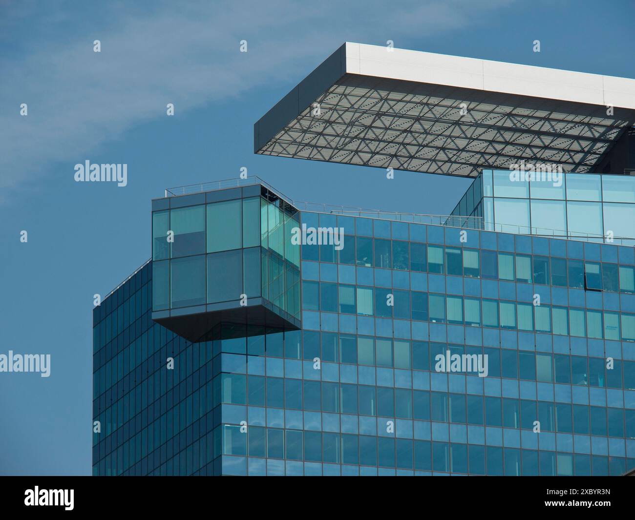 A modern glass building with a striking glass structure protruding from ...