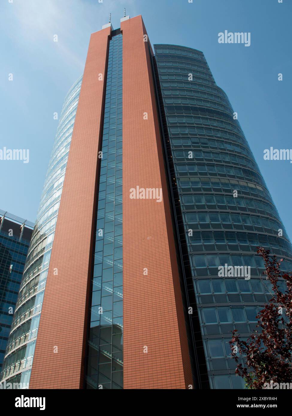 A modern high-rise building with a red facade and large glass windows ...