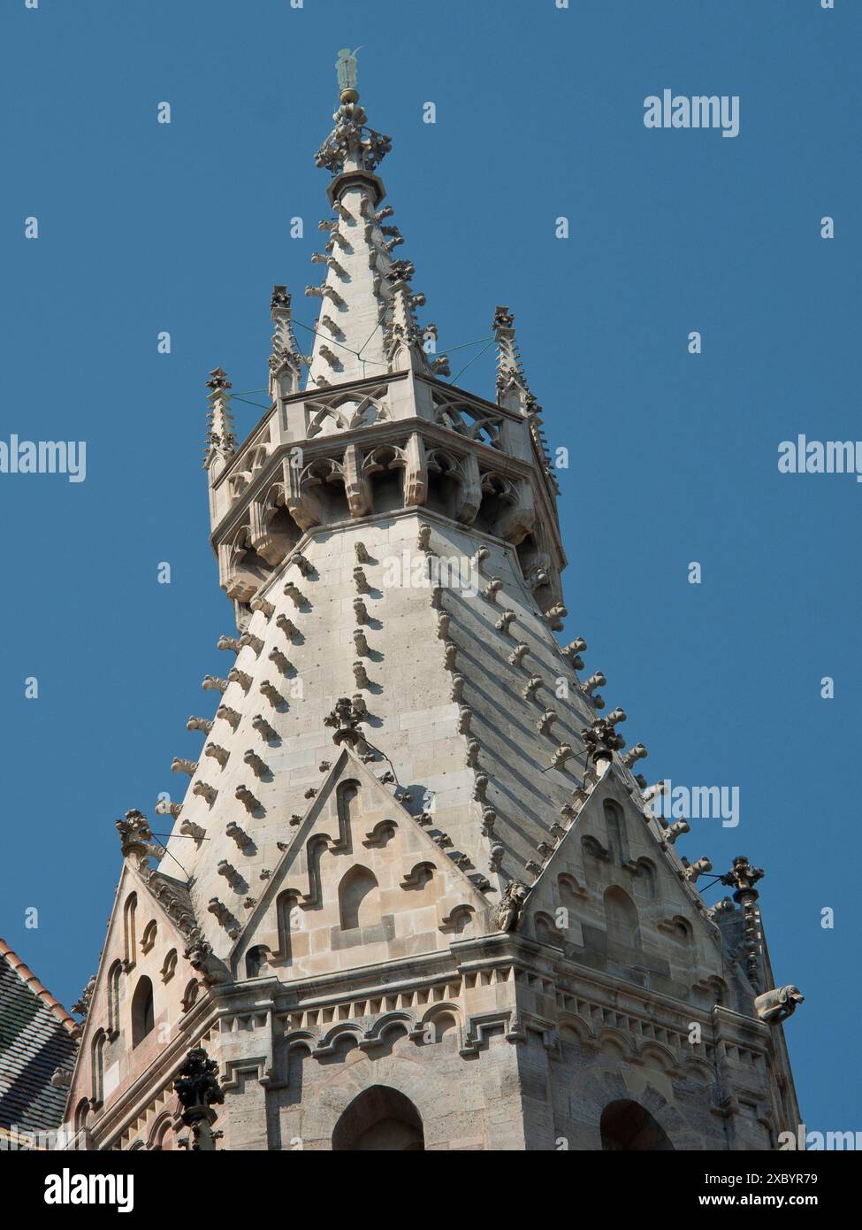 Ornate gothic church tower with many details in front of a clear sky ...