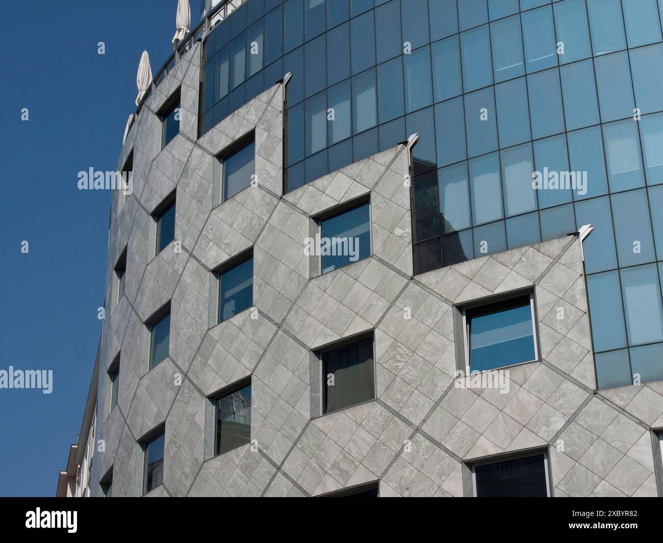 A modern building with a facade of glass windows and geometric patterns ...