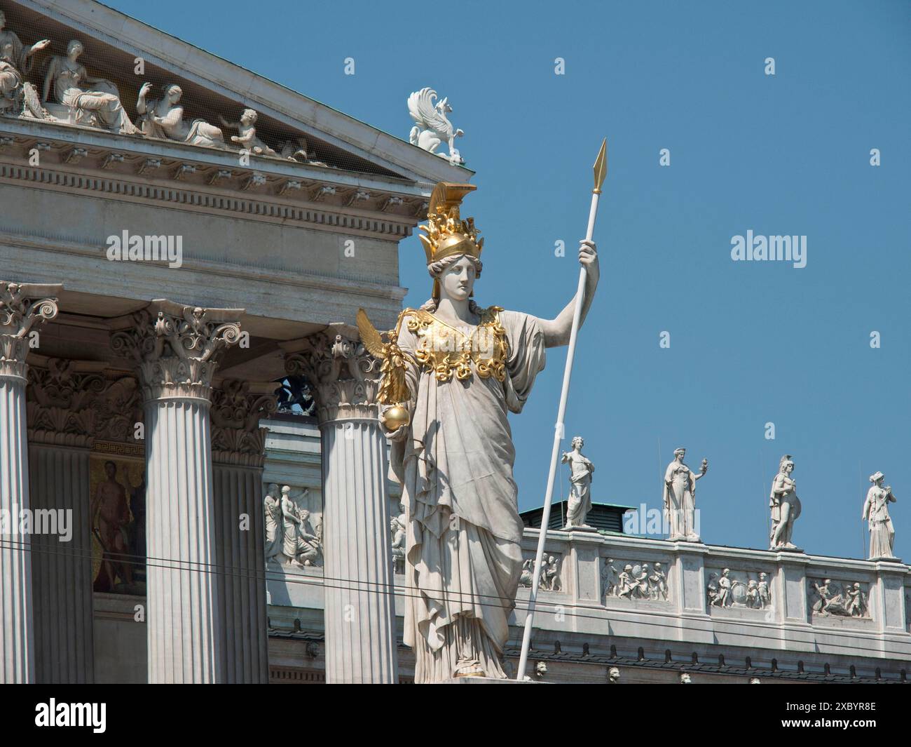 A statue of Pallas Athena holding a spear in front of a building with ...
