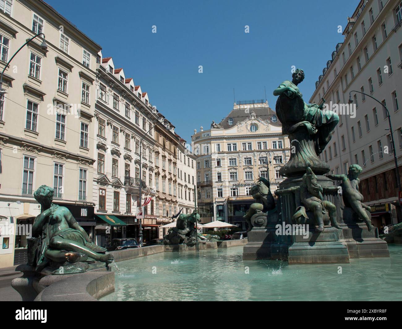 A fountain with several bronze sculptures in a square surrounded by ...