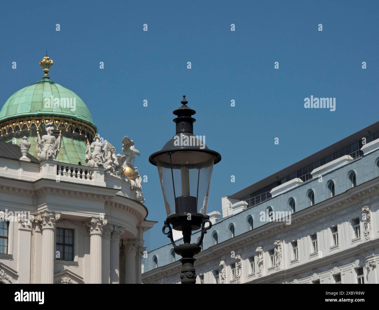 Baroque architecture with copper-green dome and statues on a white ...