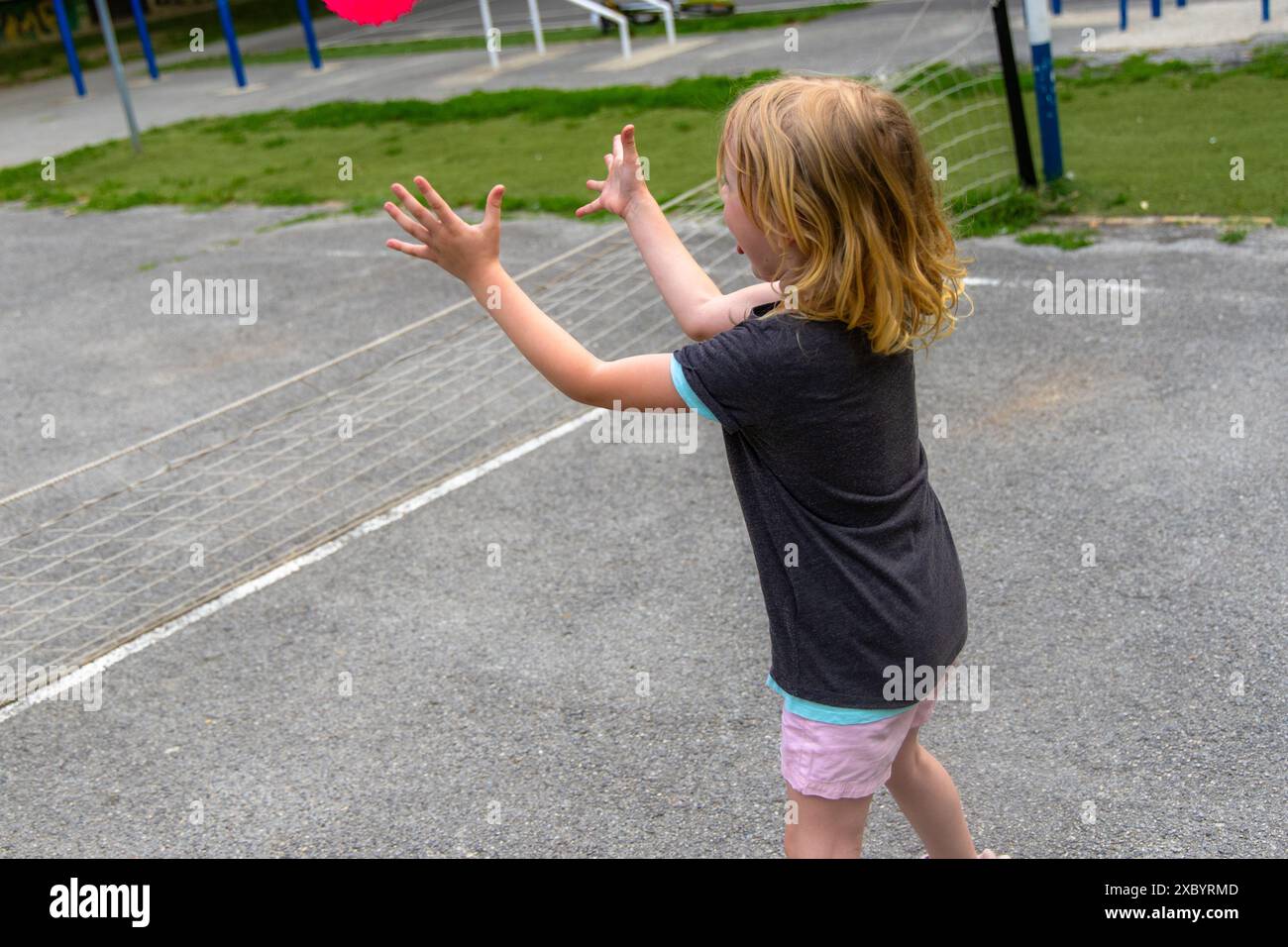 Young Girl Reaches For A Red Disc While Playing On A Playground Stock ...