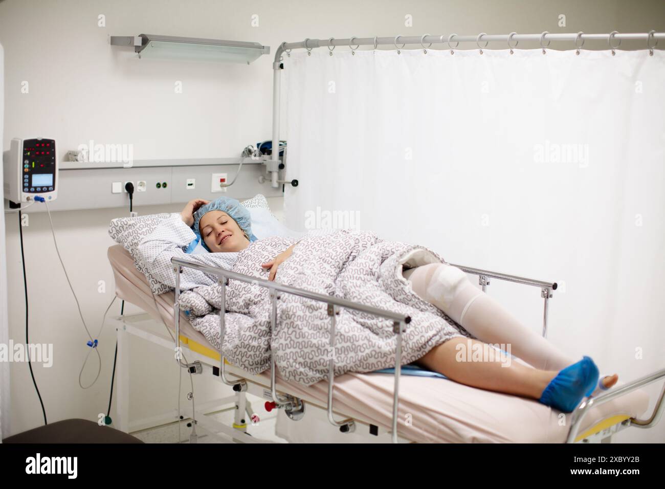 Young patient recovering after surgery in post operative care room in ...
