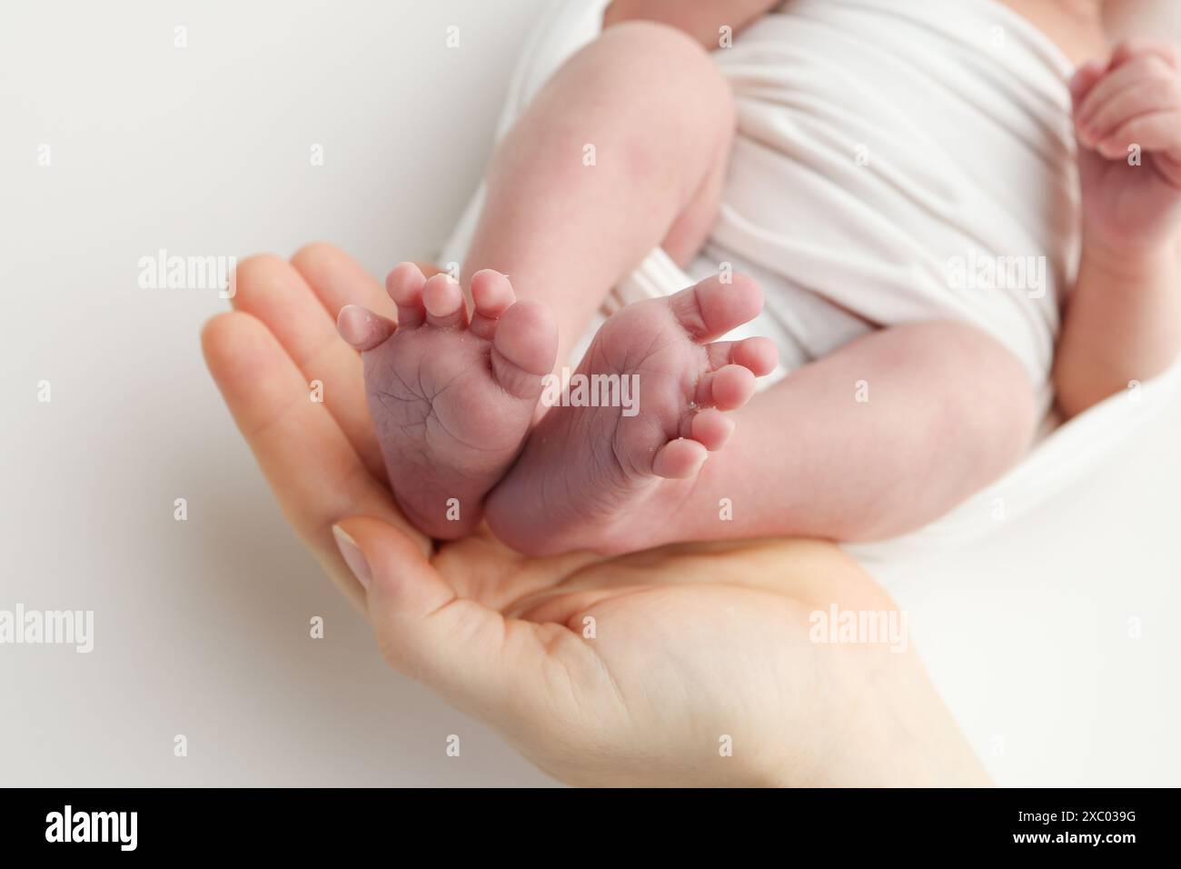 The palms of the father, the mother are holding the foot of the newborn ...