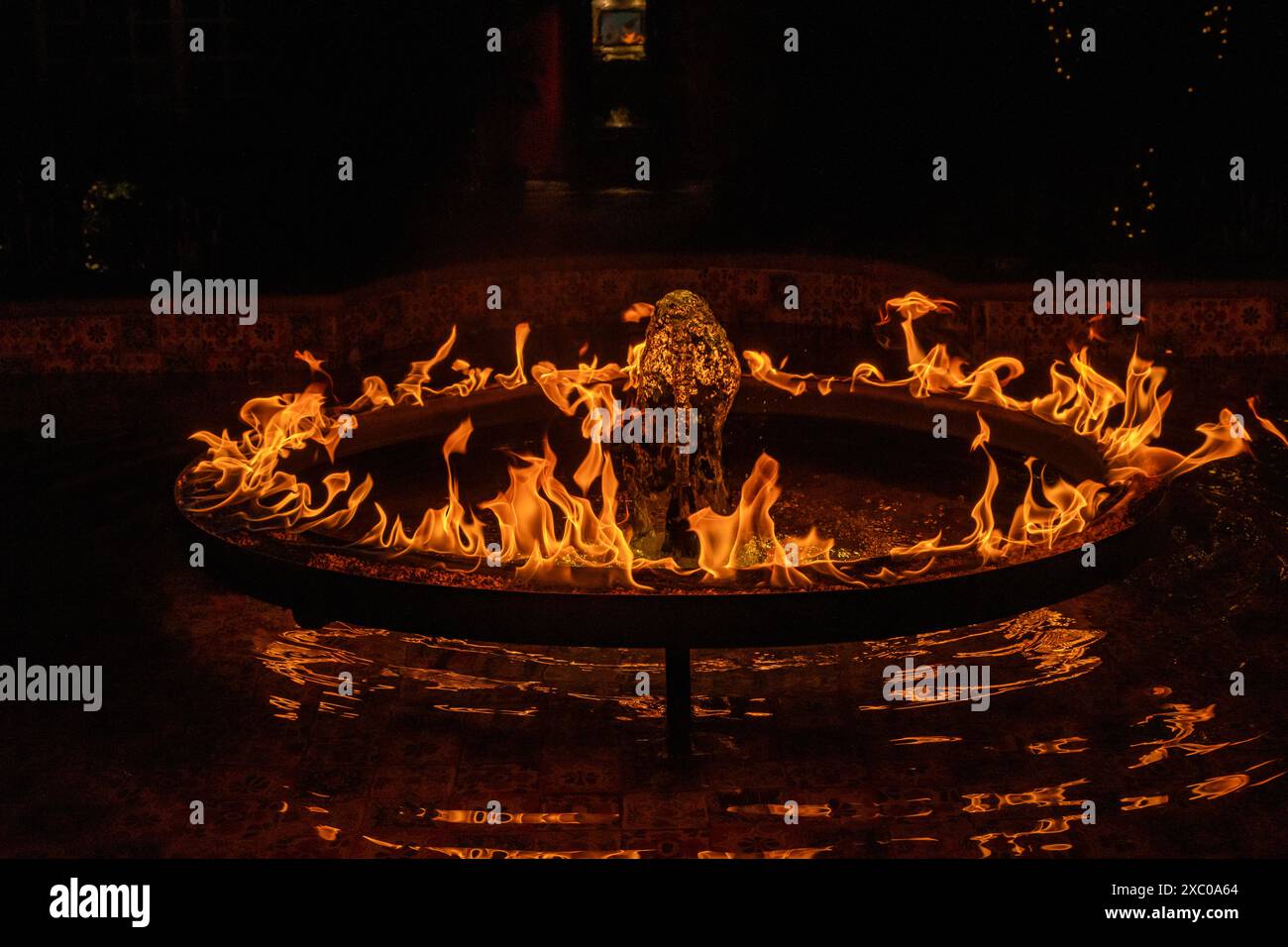 Night photograph of A ring of fire over a fountain of water in the ...