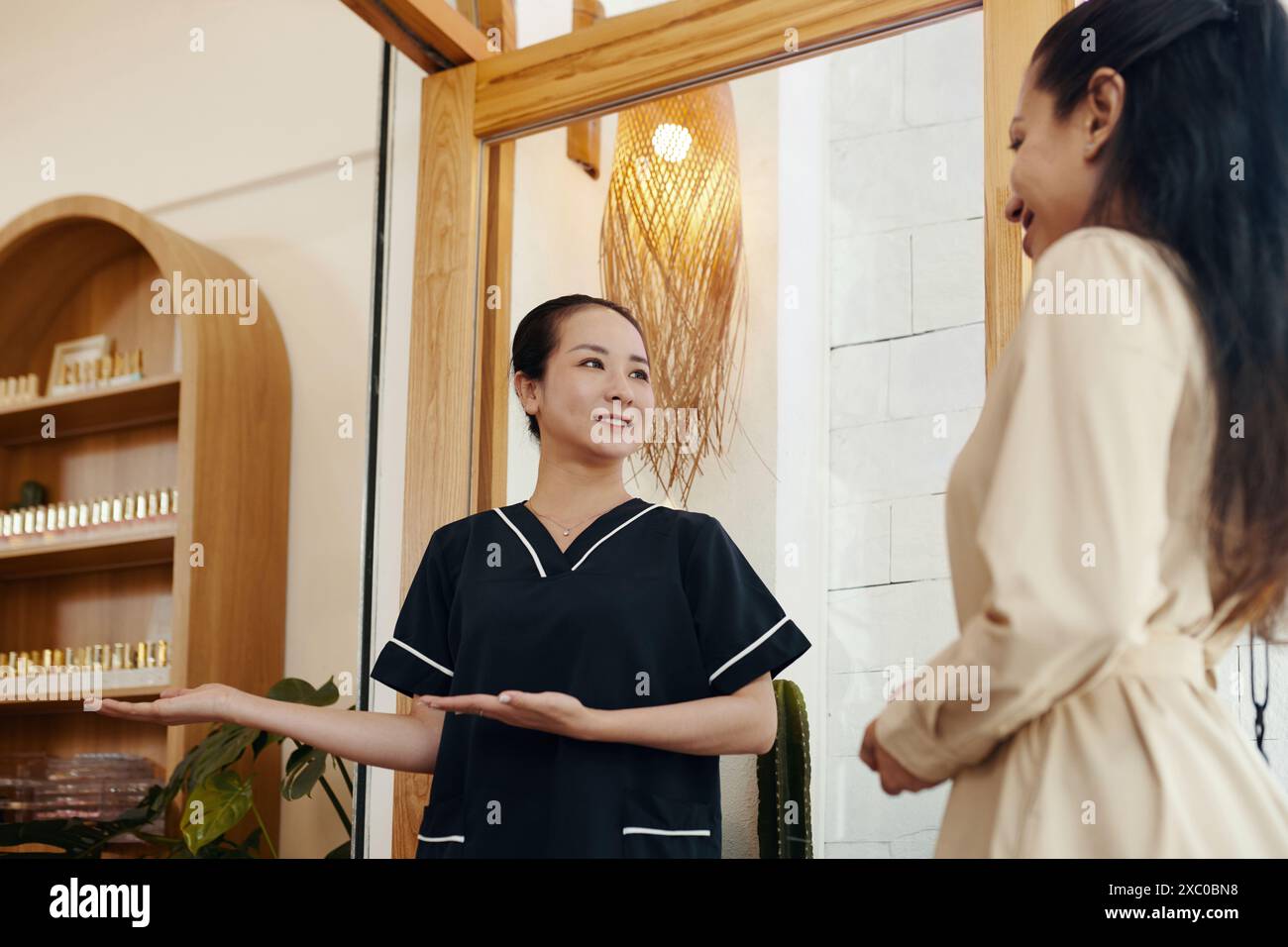 Spa salon administrator meeting new client and welcoming inside Stock ...