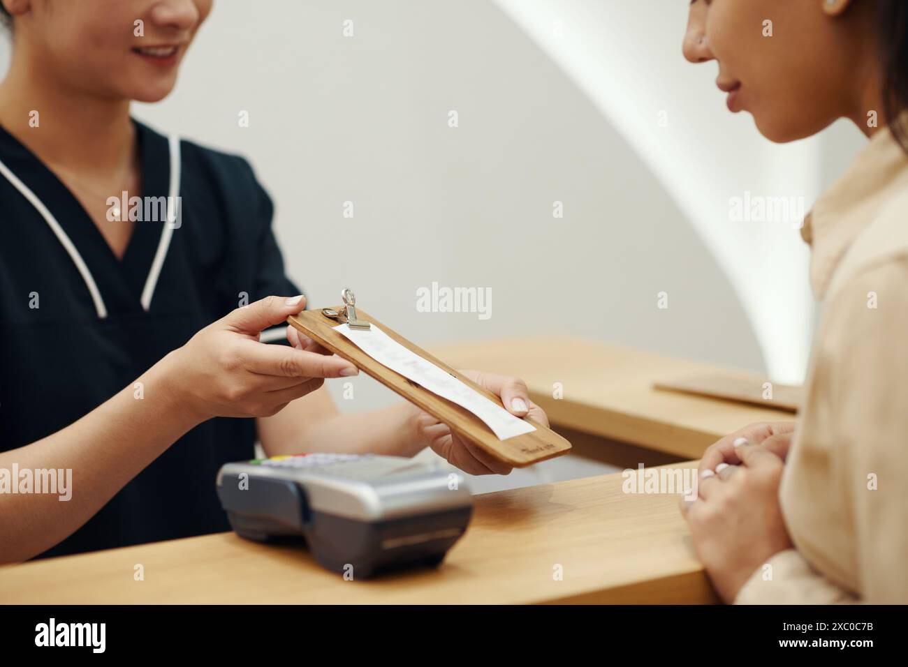 Cropped image of spa salon manager showing receipt with list of ...