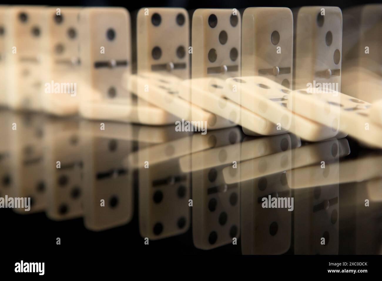 Dominoes falling in a row. Domino effect concept Stock Photo - Alamy