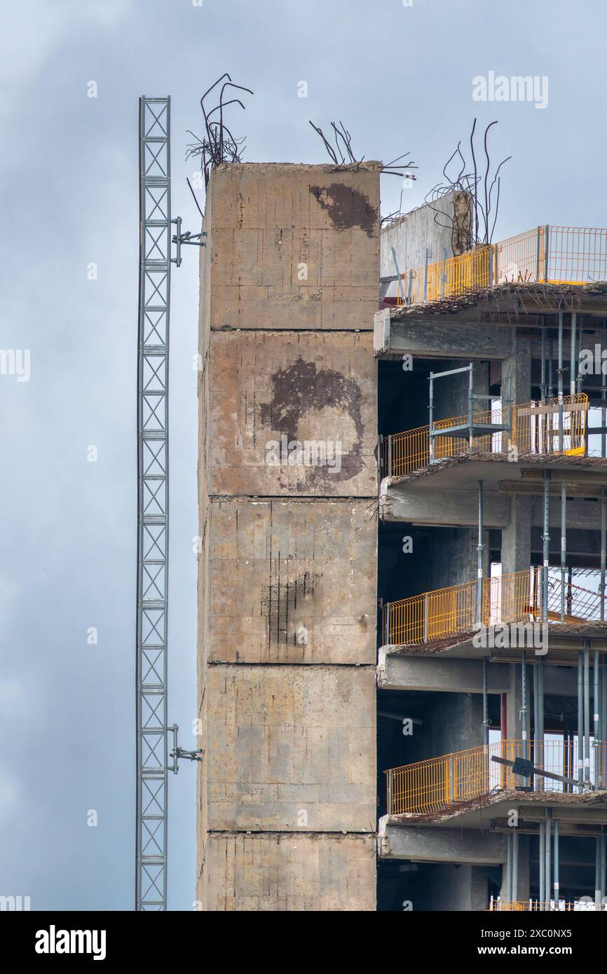 An unfinished high-rise building with exposed concrete and rebar under ...