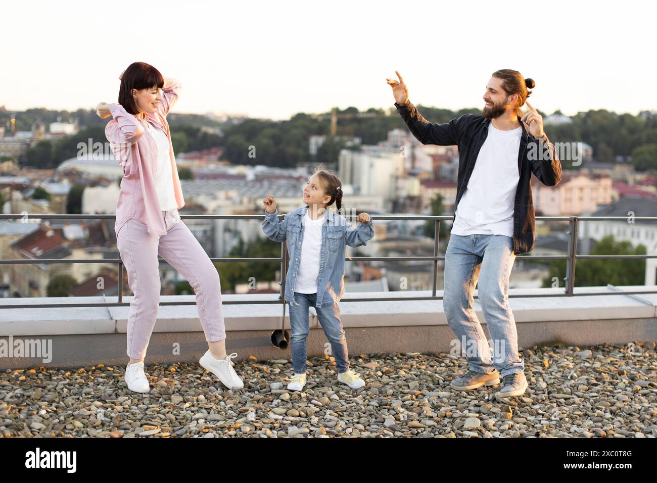 Outdoor family fun with parents and child dancing on rooftop Stock ...