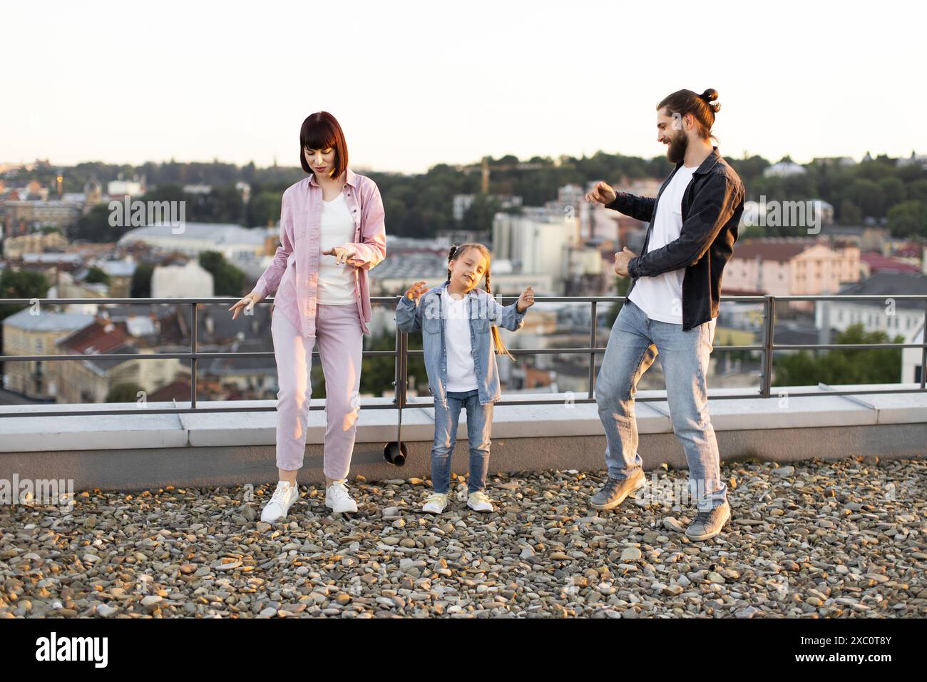 Family dancing together on rooftop with city view Stock Photo - Alamy