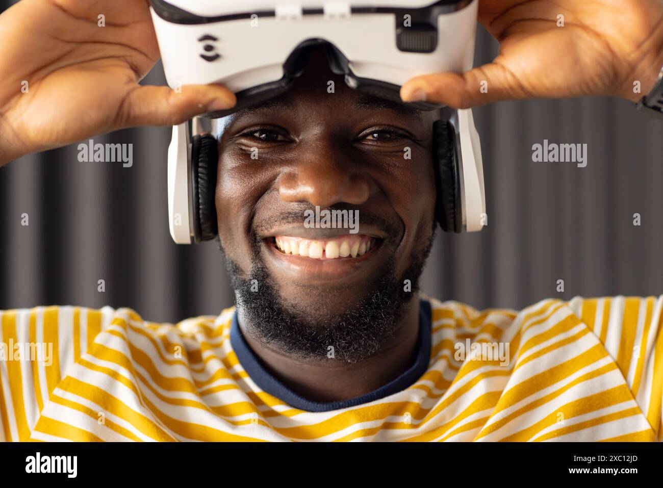 African American man smiling while using virtual reality headset Stock ...