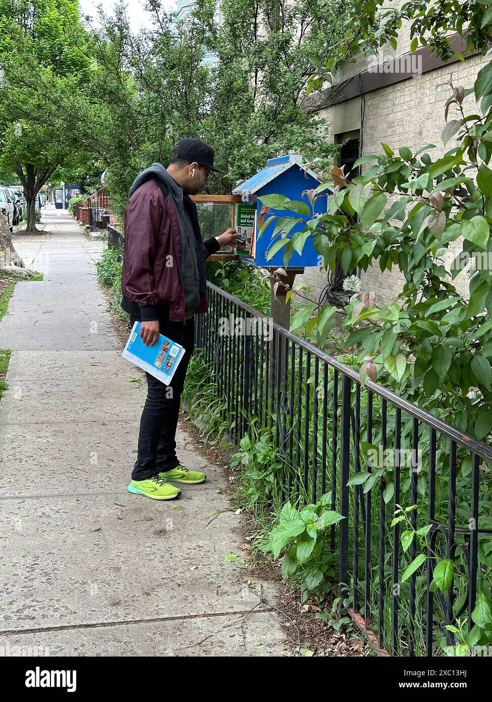 Man choosing book from Little Free Library book-sharing box in the ...