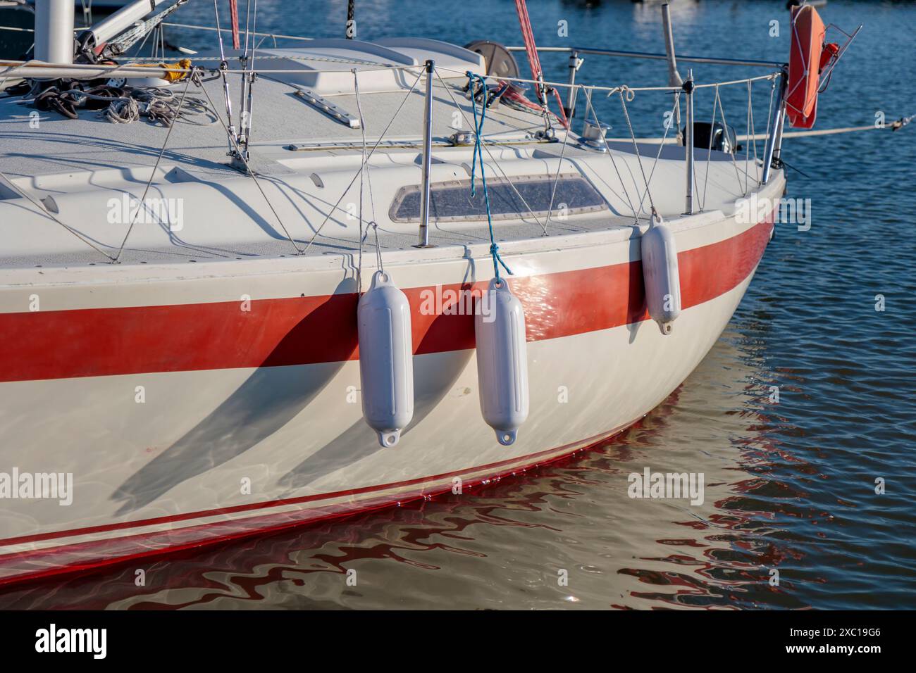 Docked boat with white fenders hanging alongside vessel, sunny summer ...