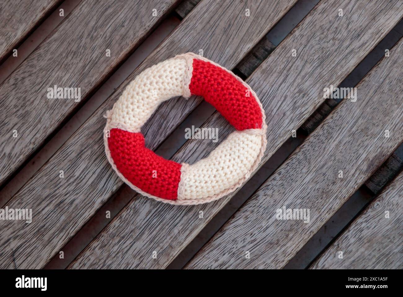 Handmade small crocheted toy lifebelt on the wood Stock Photo - Alamy