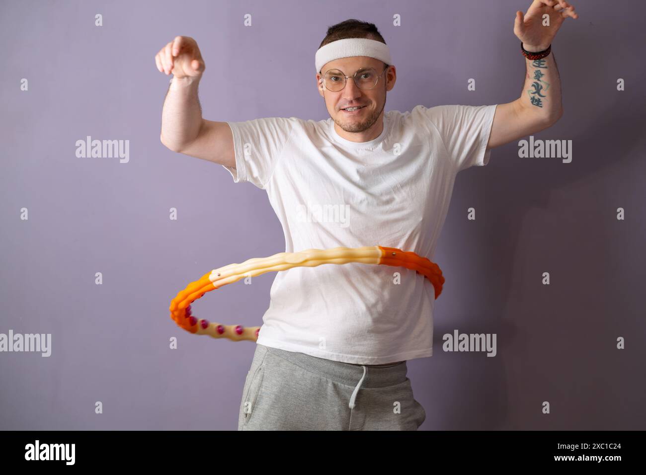 Man In White T-Shirt And Headband Using A Weighted Hula Hoop For ...