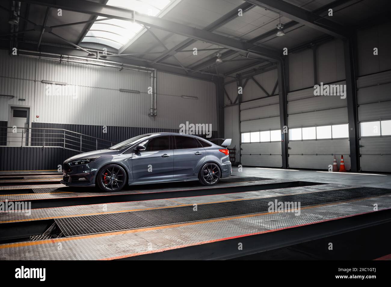 grey Ford Focus ST in big airy garage. Side view of sedan parked in ...