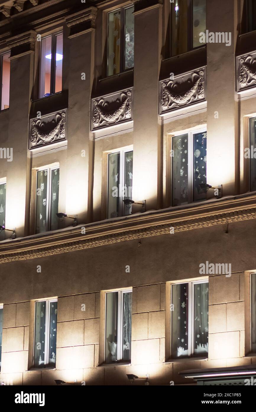 At night, a building with numerous windows is brightly illuminated ...