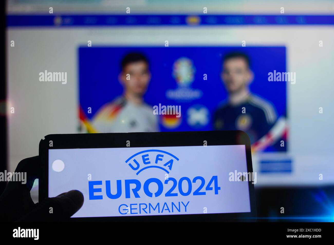 holding a mobile phone with the UEFA Euro 2024 European football ...