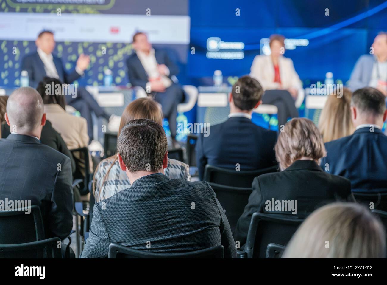Audience members listening attentively to speakers during a business ...