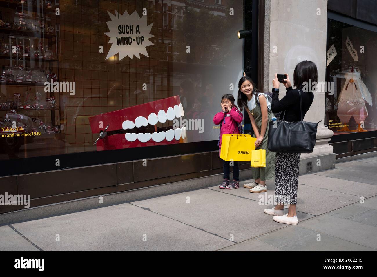 Passers-by and shoppers interact with a large set of wind-up chattering ...