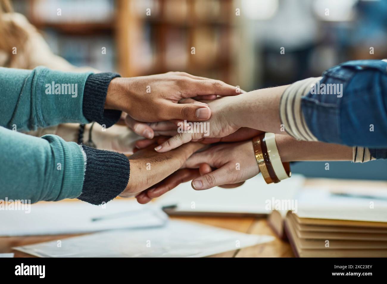 Students, group and hands together in library for learning, knowledge ...