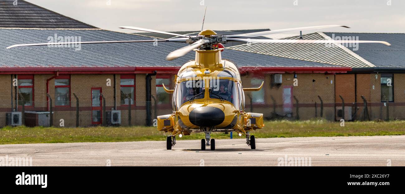 Yellow NHV helicopter with black nose taxiing at Blackpool Airport ...