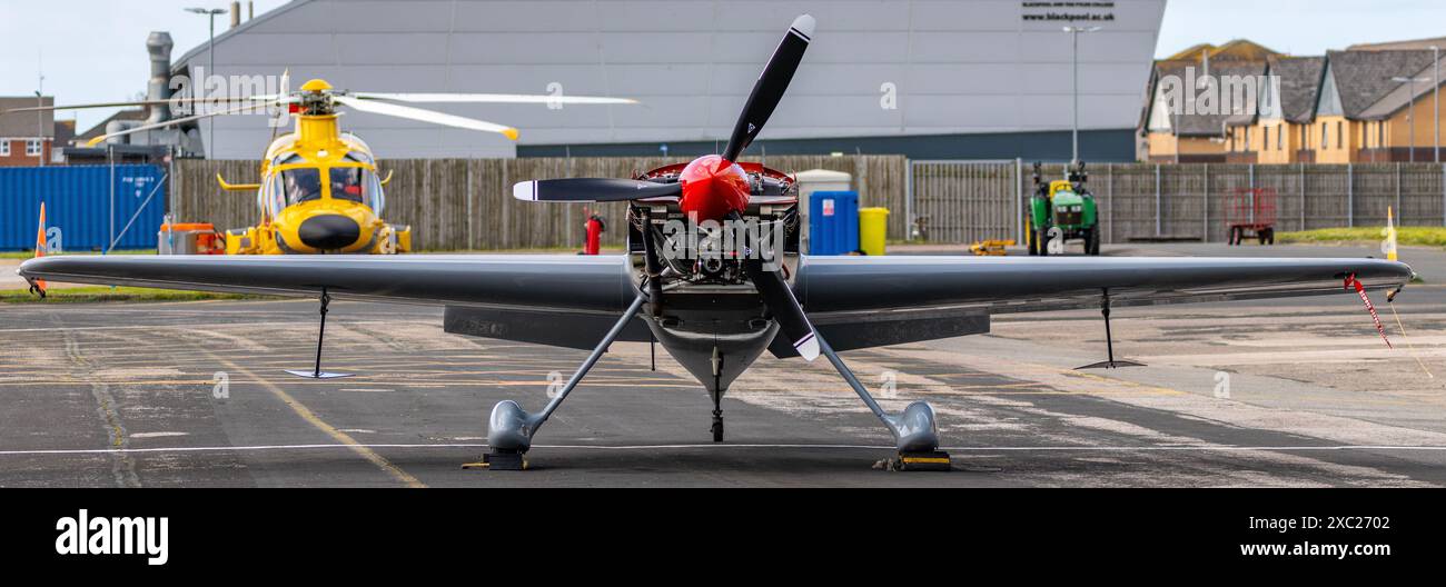 Red nosed aerobatic aircraft parked in front of yellow helicopter Stock ...