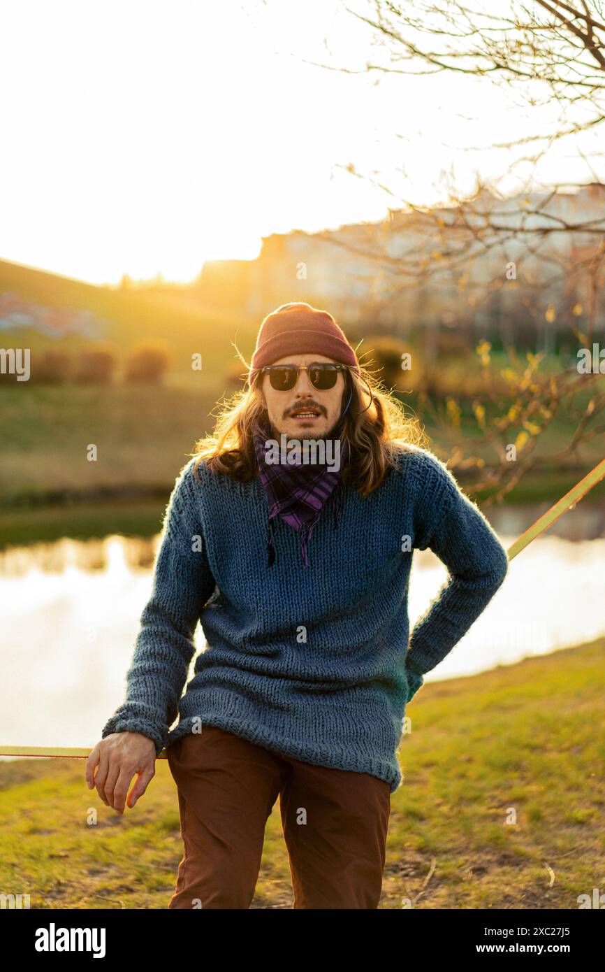 Young man sitting on a slackline Stock Photo - Alamy