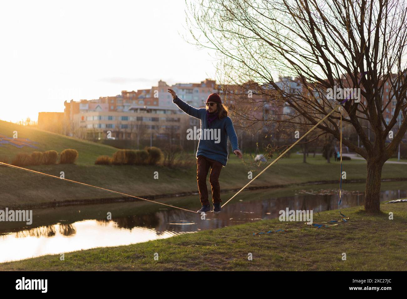 Young man balancing on slackline Stock Photo - Alamy